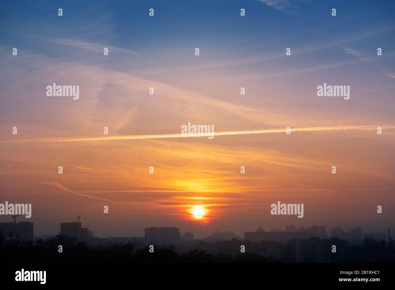Dramatic colorful sunset or sunrise sky landscape with line row of city ...