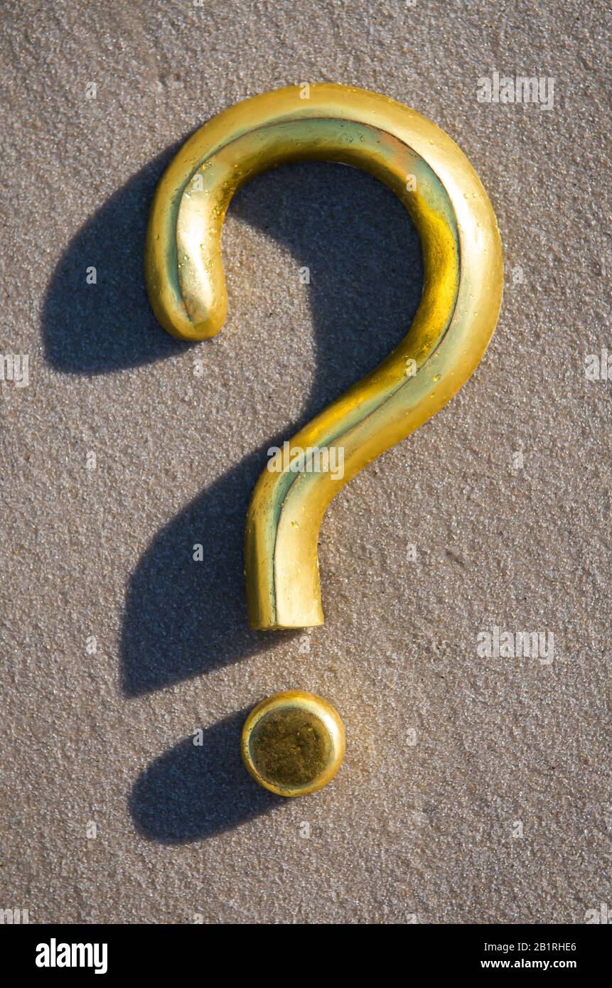 Gold question mark shining outdoors on the beach on textured sand Stock ...