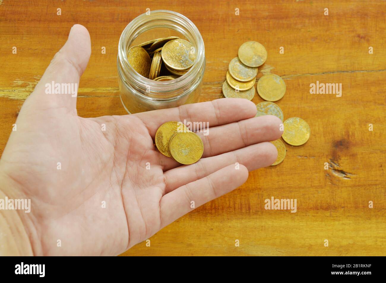 gold coin on human hand for saving Stock Photo - Alamy