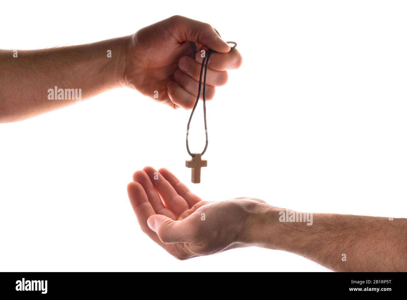 Hand giving to another hand a pendant with cross isolated white ...