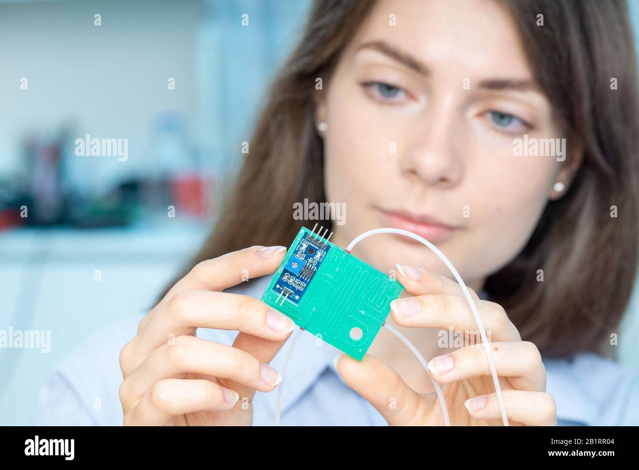 Young scientist woman in microbiological lab with lab-on-chip LOC ...