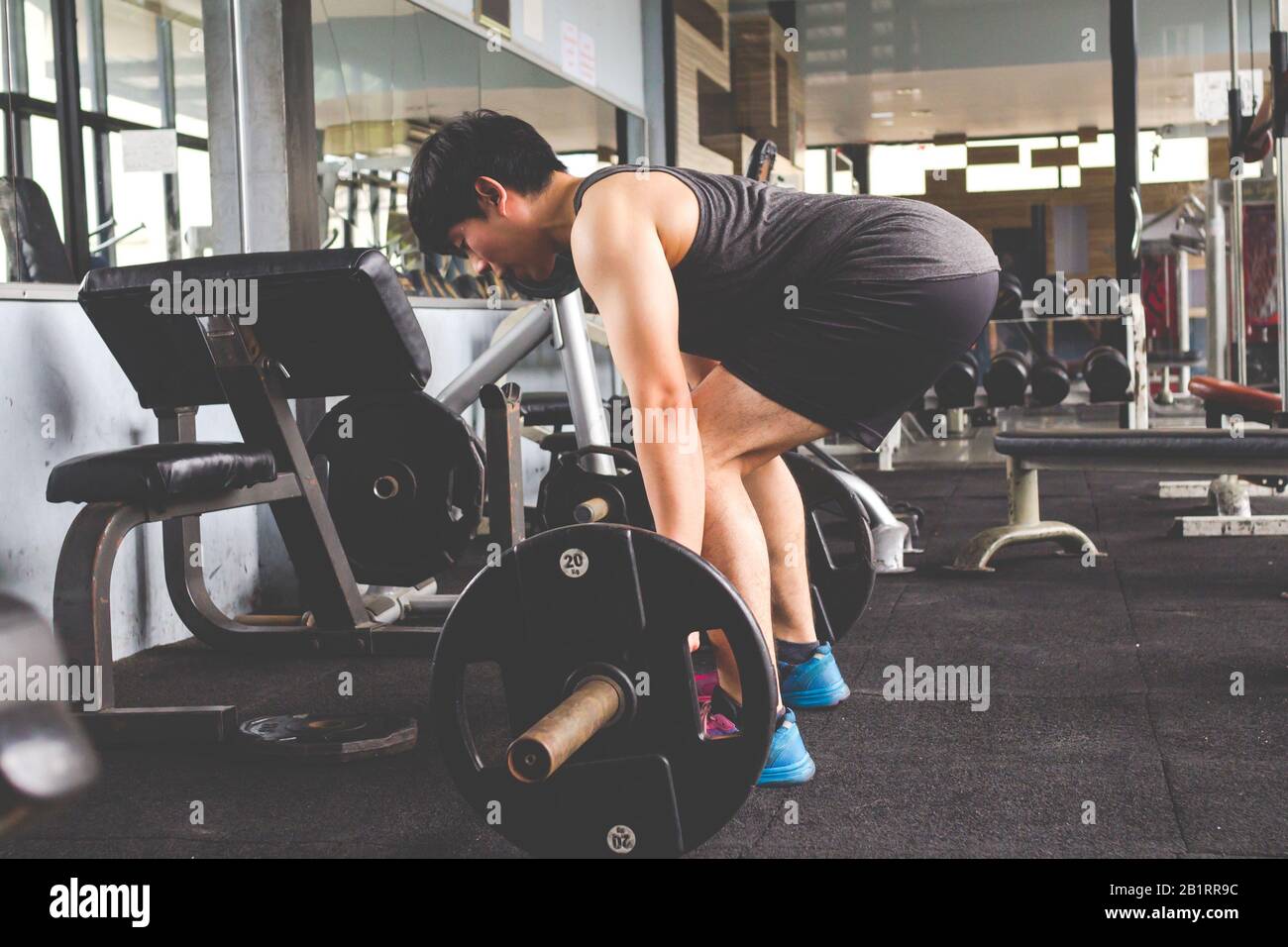 The young man who beginner training with barbell in gym. Fitness ...