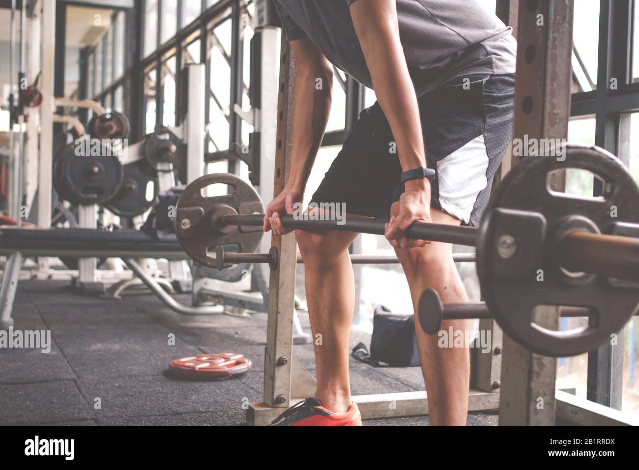 The young man who beginner training with barbell in gym.Fitness ...