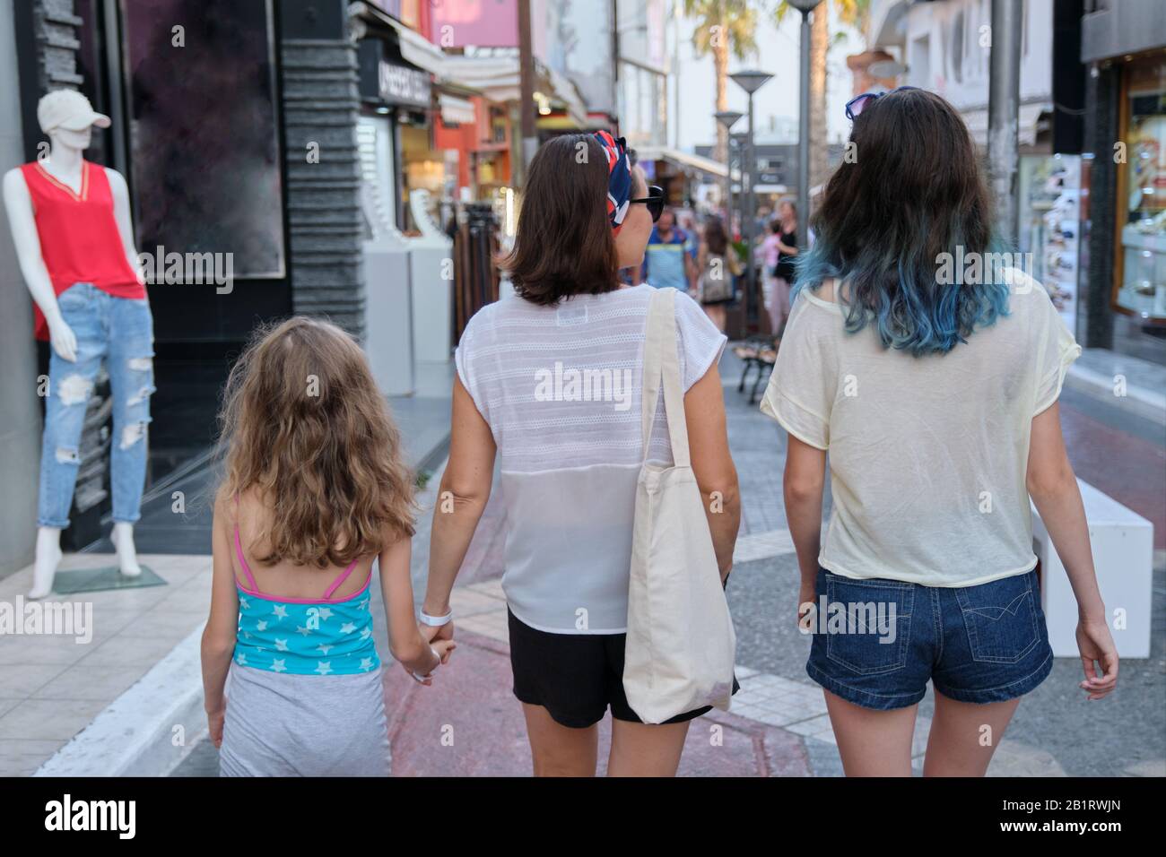 People walking along street of small resort town, back view Stock Photo ...
