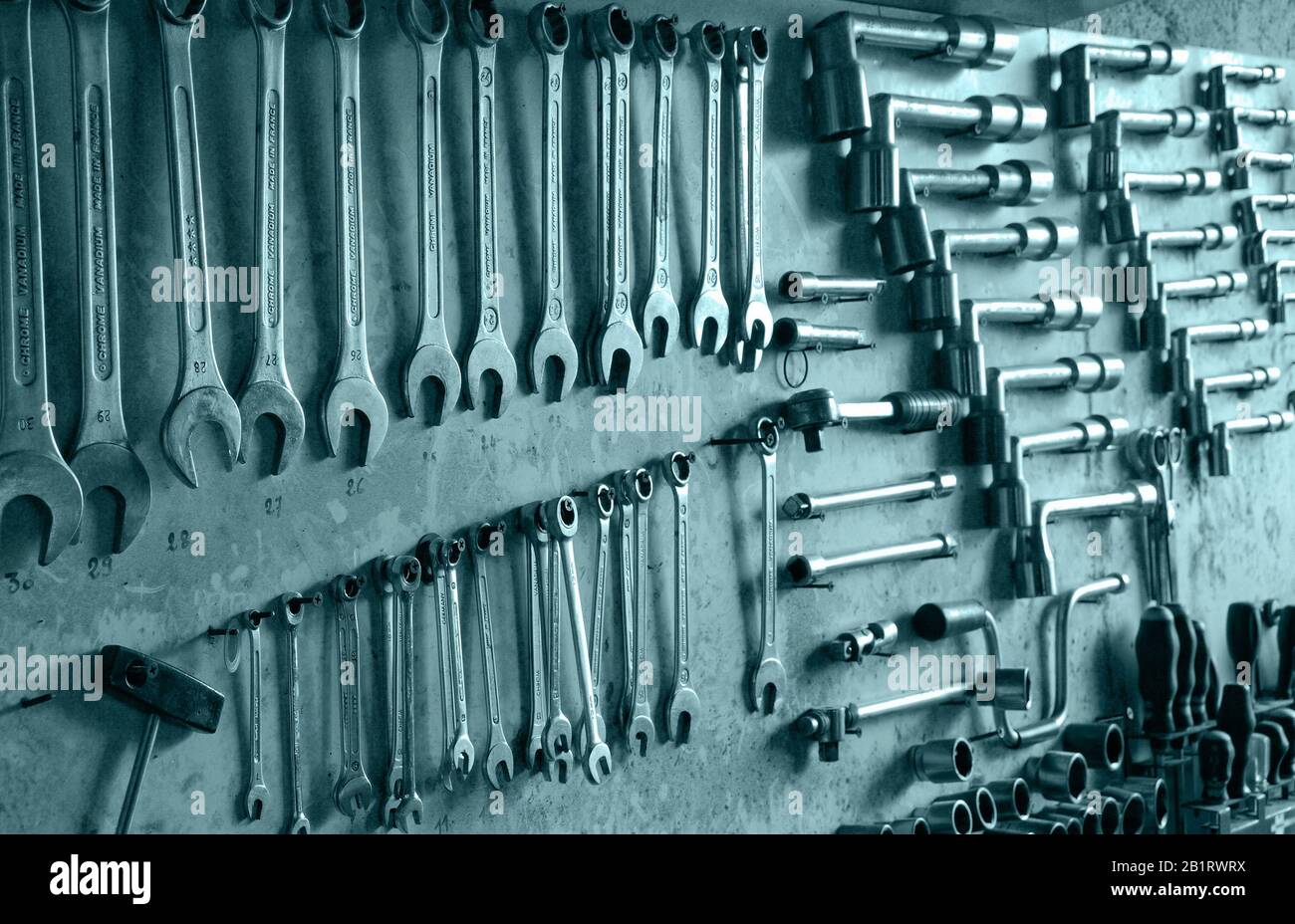 Tools hanging on wall in blue toned ambiance Stock Photo - Alamy