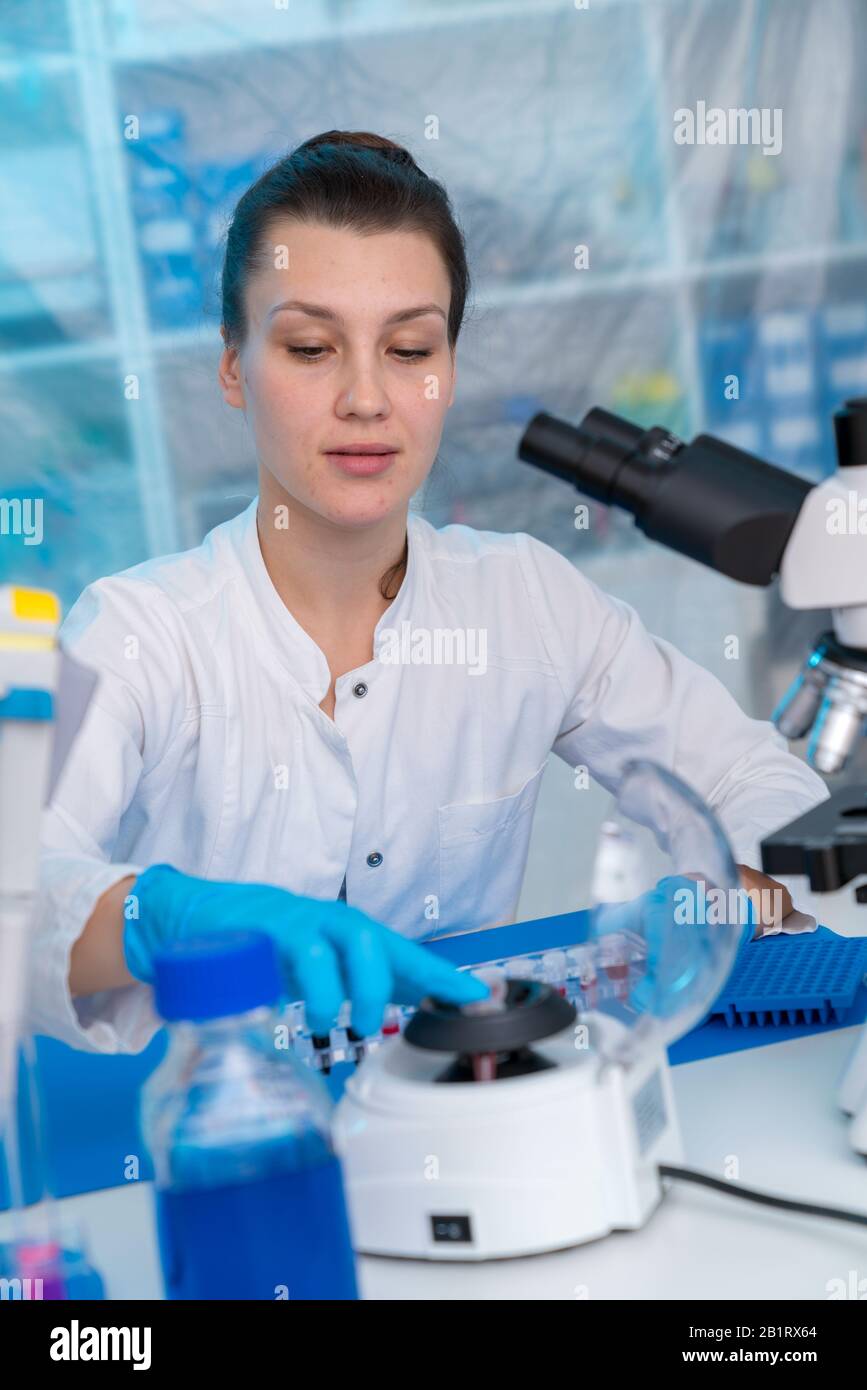 Young woman in clinical lab does PCR test on viral disease Stock Photo ...