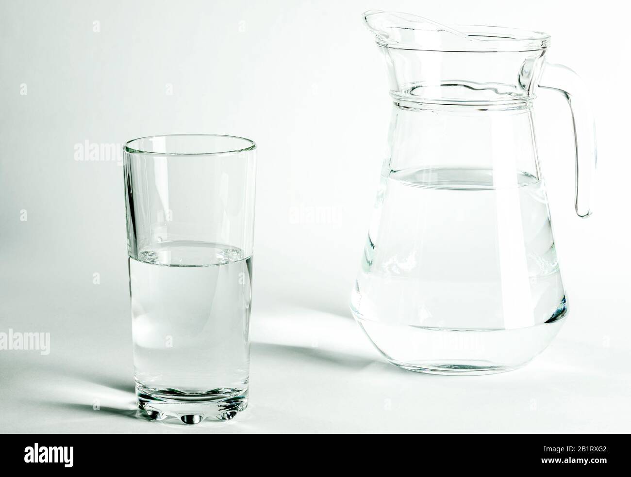 Pure clear water in a glass and jug stands on a white background Stock ...