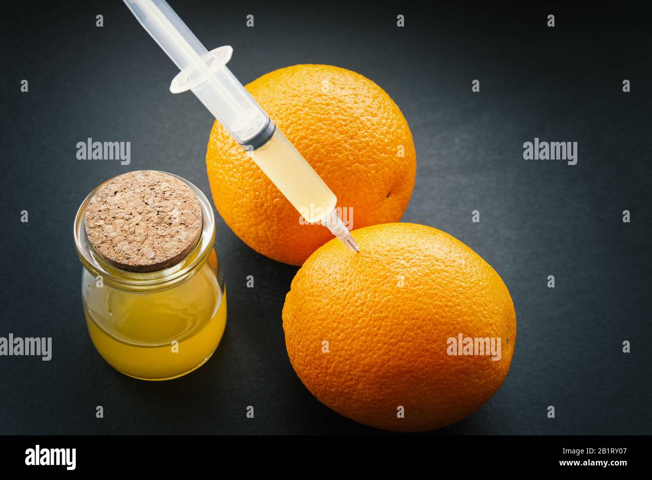 Orange with syringe injection colored liquid Stock Photo - Alamy
