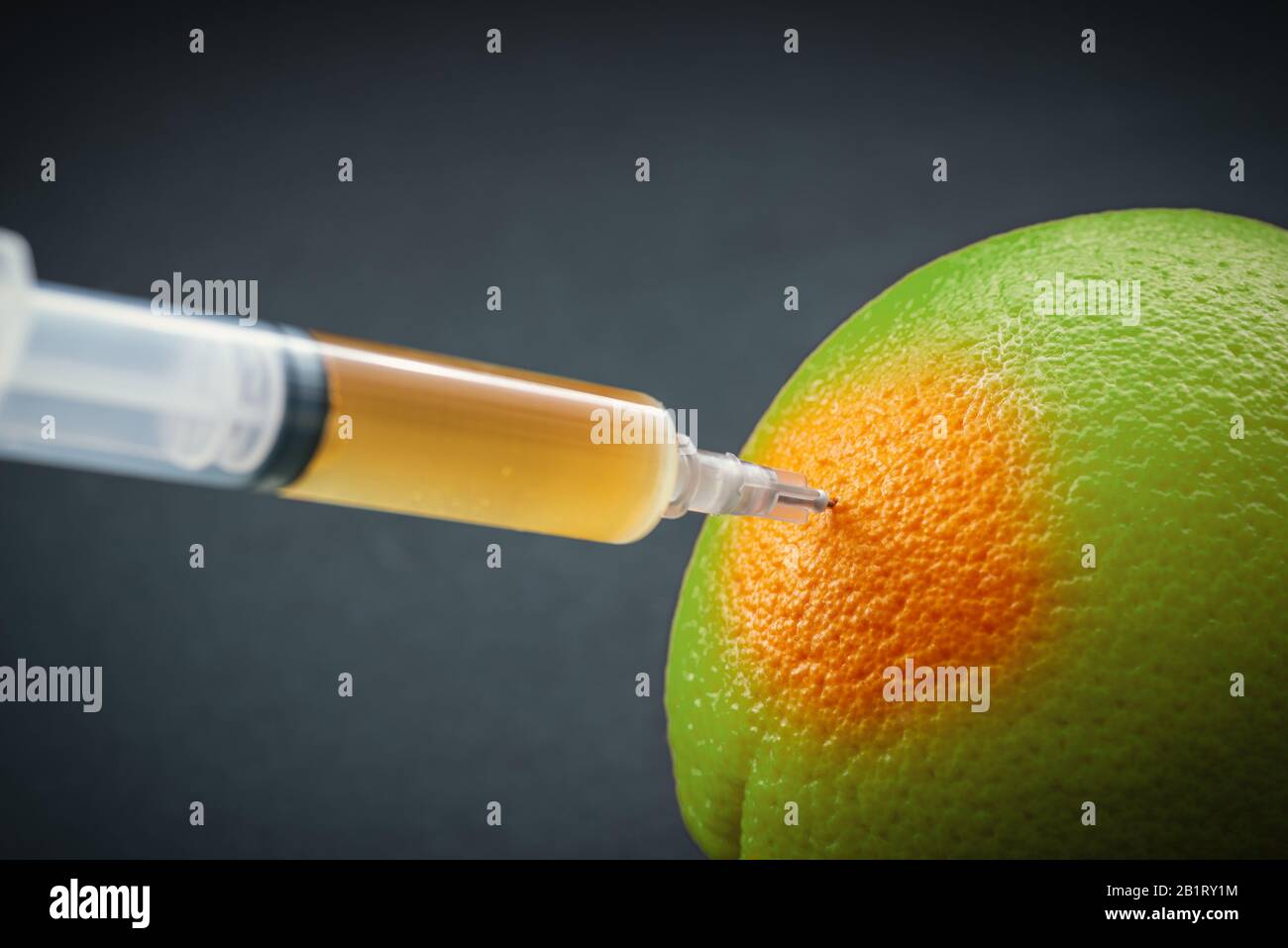 Orange with syringe injection colored liquid Stock Photo - Alamy