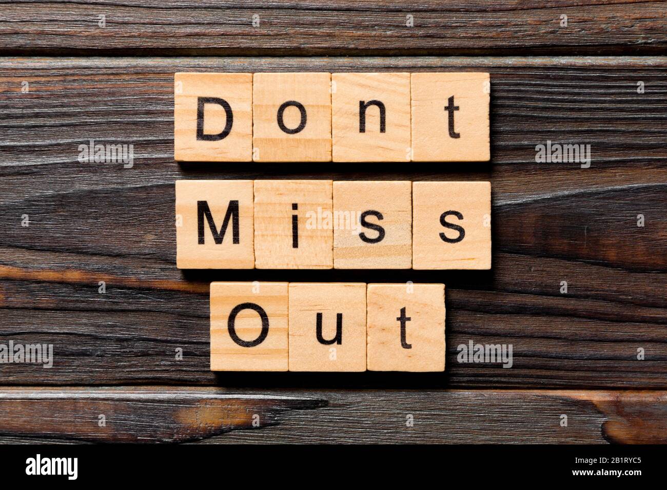 Don't miss out word written on wood block. Don't miss out text on ...