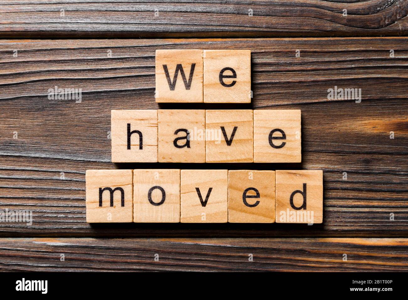 we have moved word written on wood block. we have moved text on wooden ...