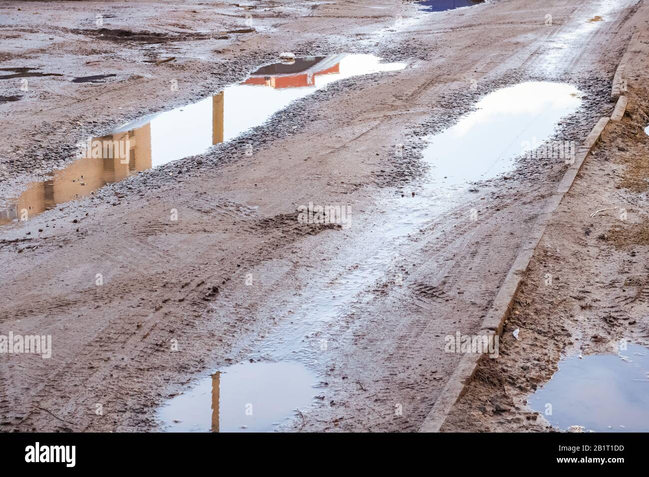 Puddles and mud on a sandy road Stock Photo - Alamy
