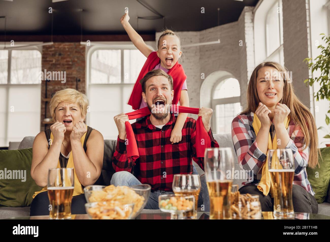 Excited, happy big family watching football, soccer, basketball, hockey ...