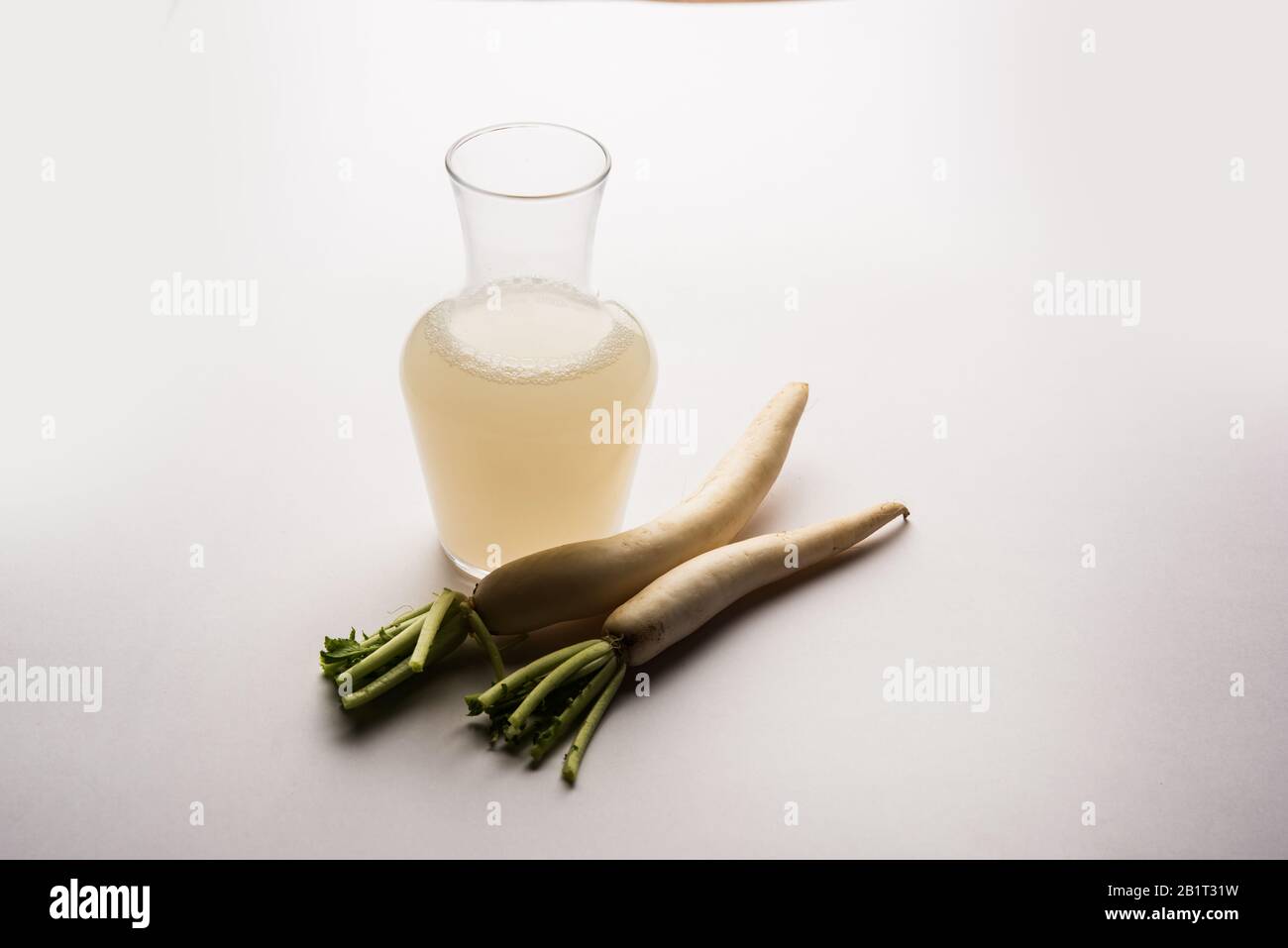 Healthy Fresh daikon juice or Mooli extract drink in a glass with raw ...
