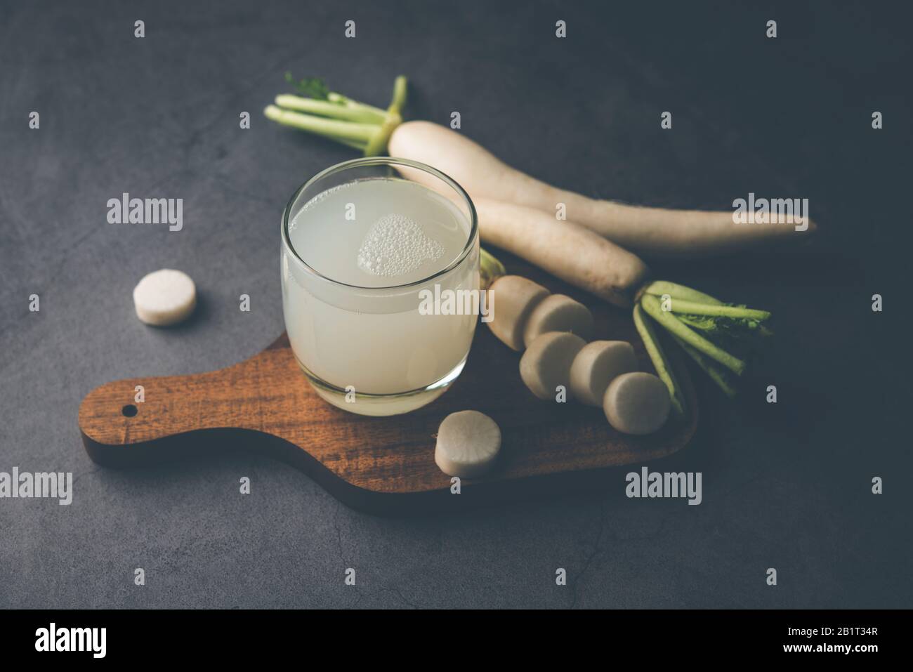 Healthy Fresh daikon juice or Mooli extract drink in a glass with raw ...