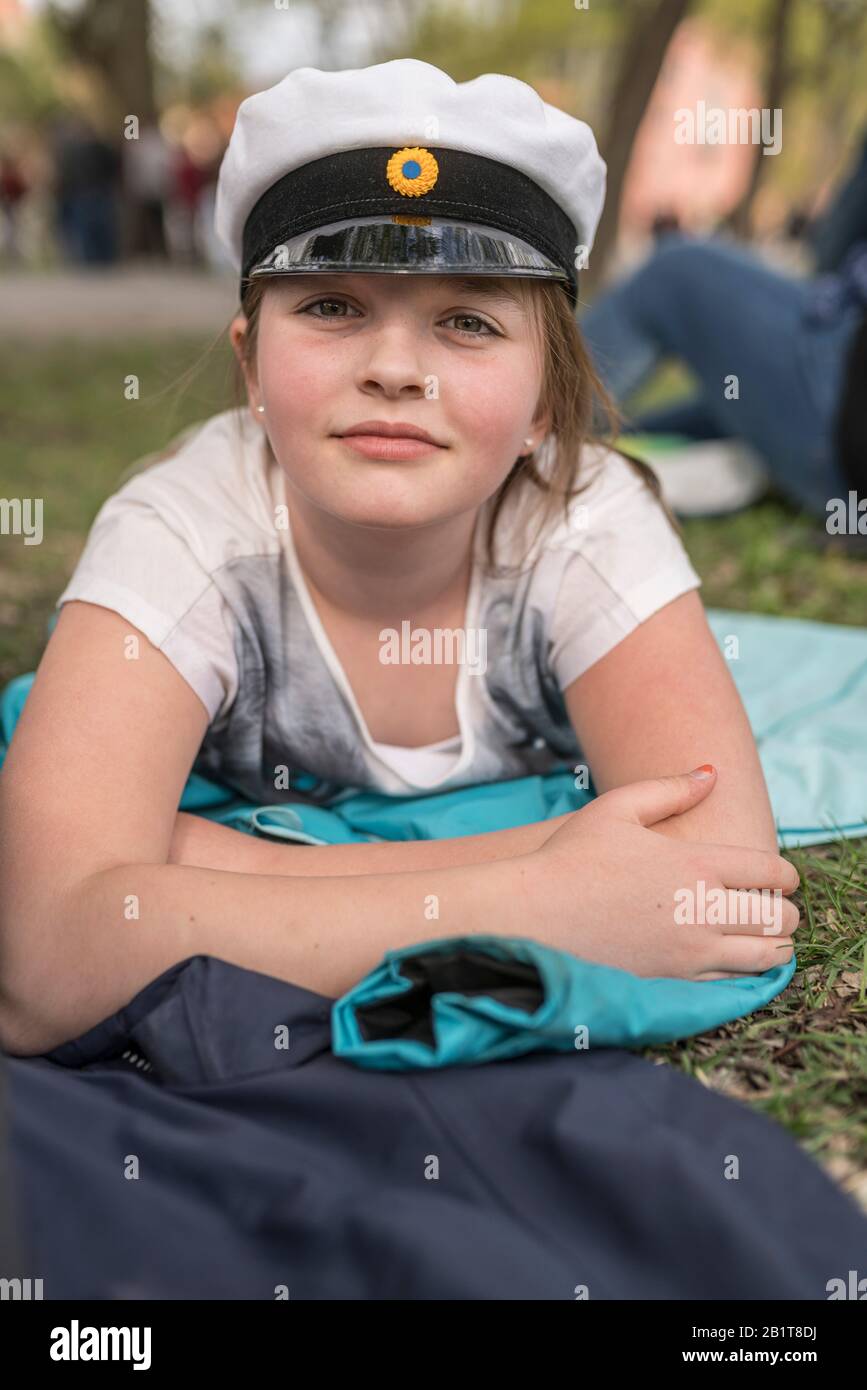 Portrait of a young girl with a traditional student hat lying on the ...