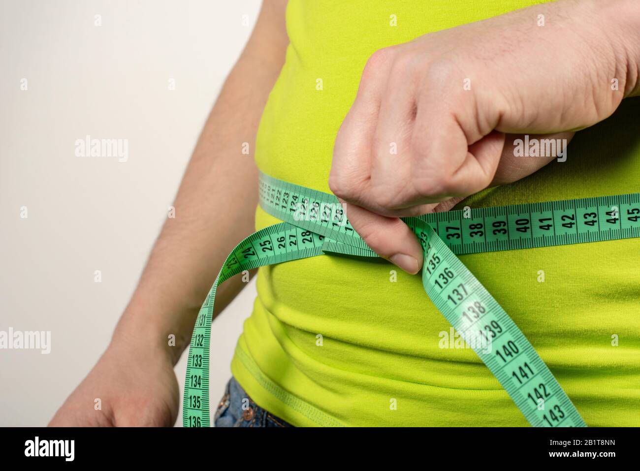 A man in blue jeans and a t-shirt with a fat belly on a white ...