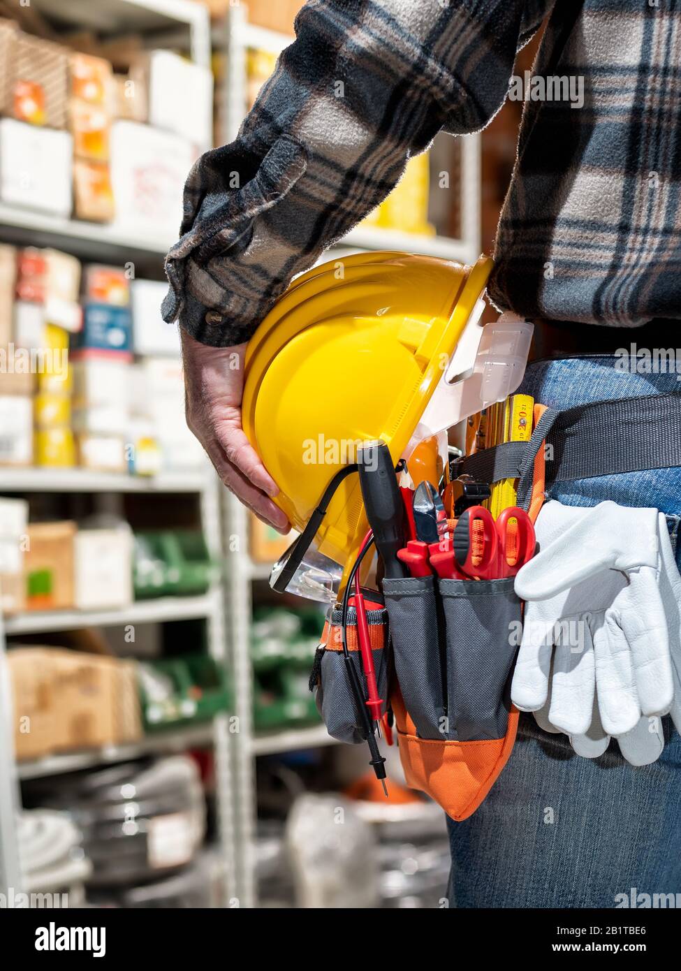 Electrician in the electrical component store holds the helmet and ...