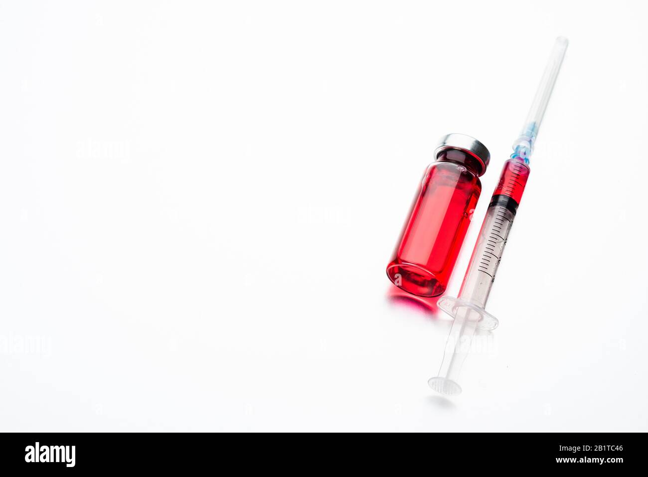 Medical ampoule with a syringe. Red medicine in a glass bottle ...
