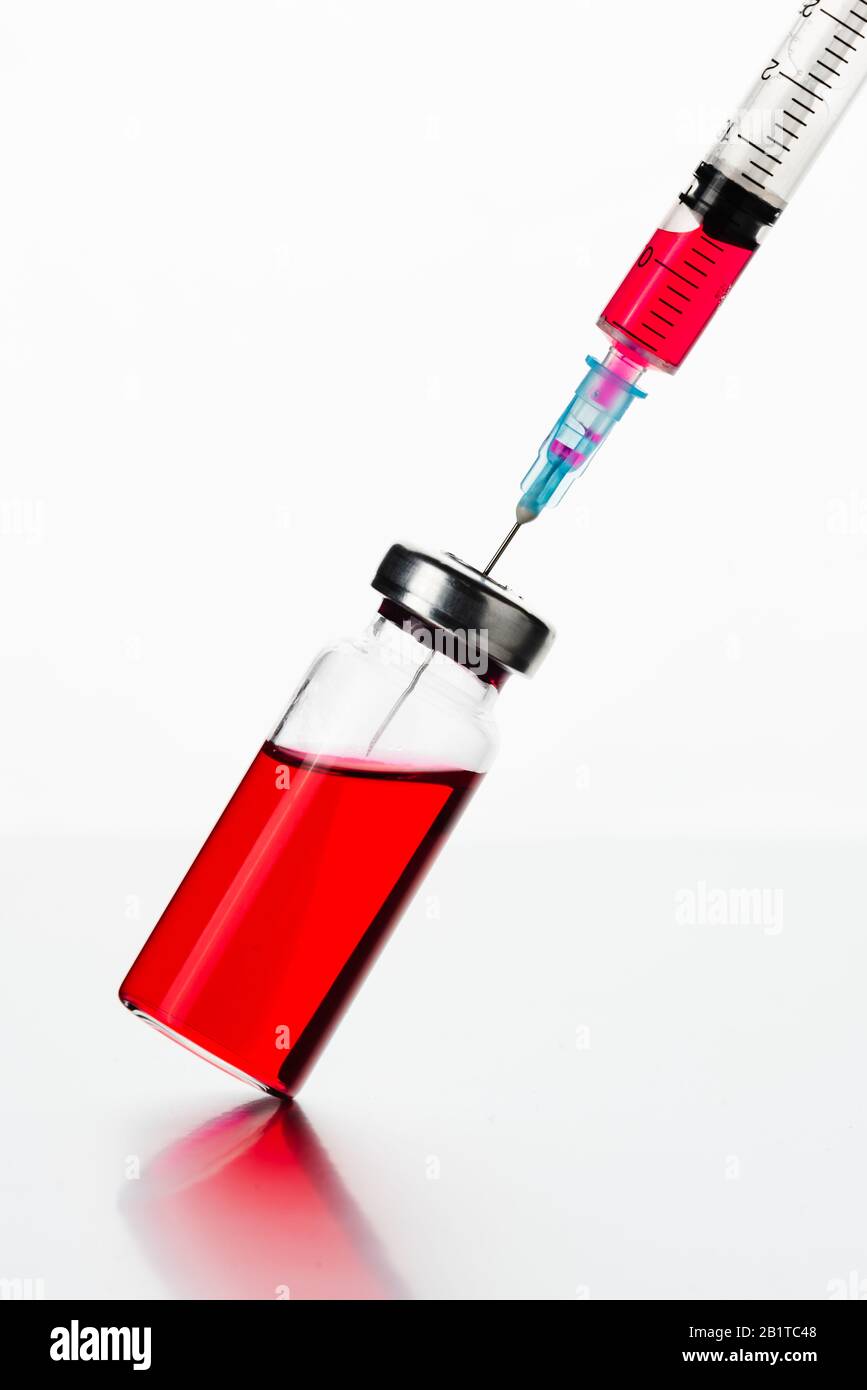 Medical ampoule with a syringe. Red medicine in a glass bottle ...
