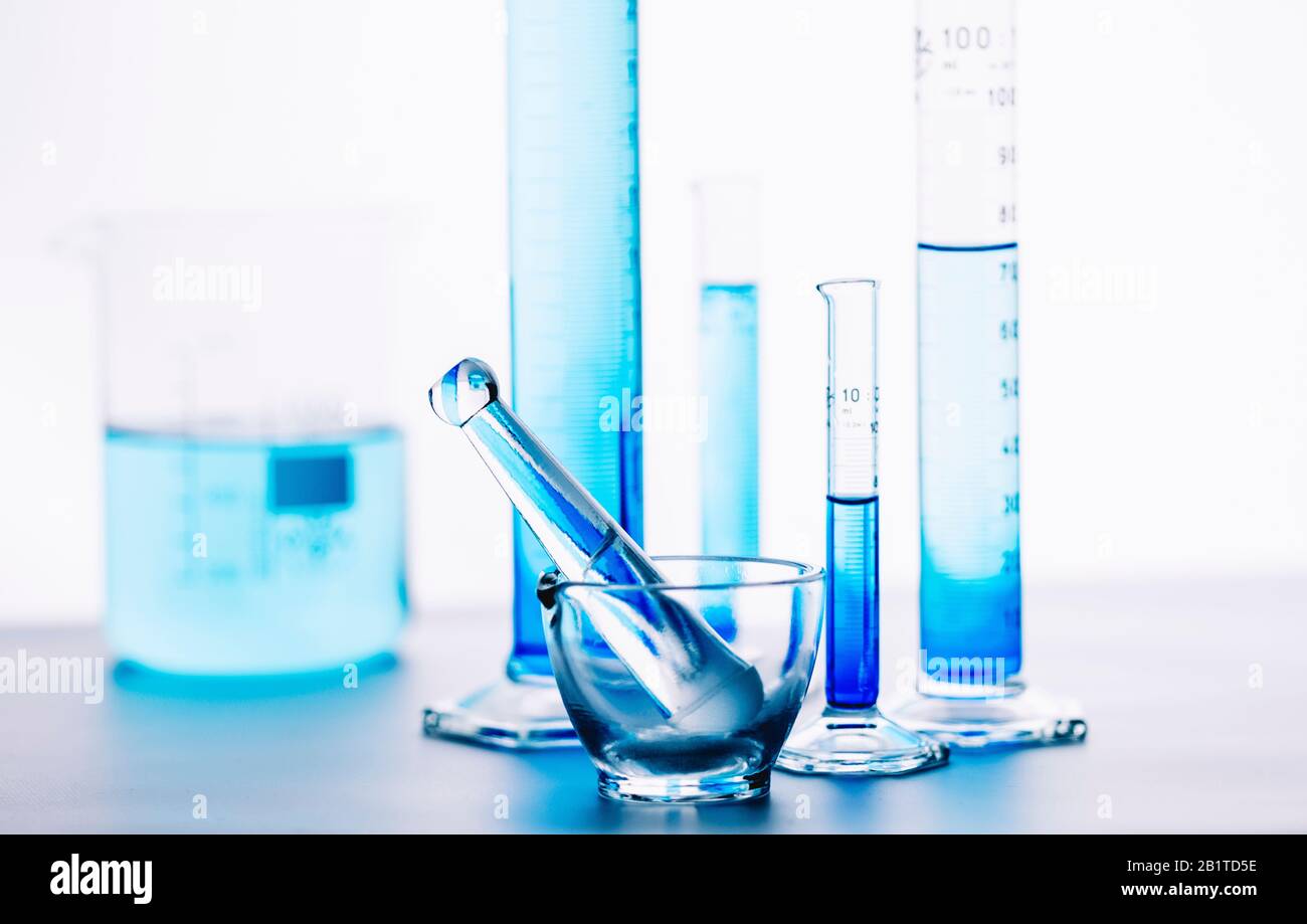 Laboratory test equipment with blue liquid inside on white background ...