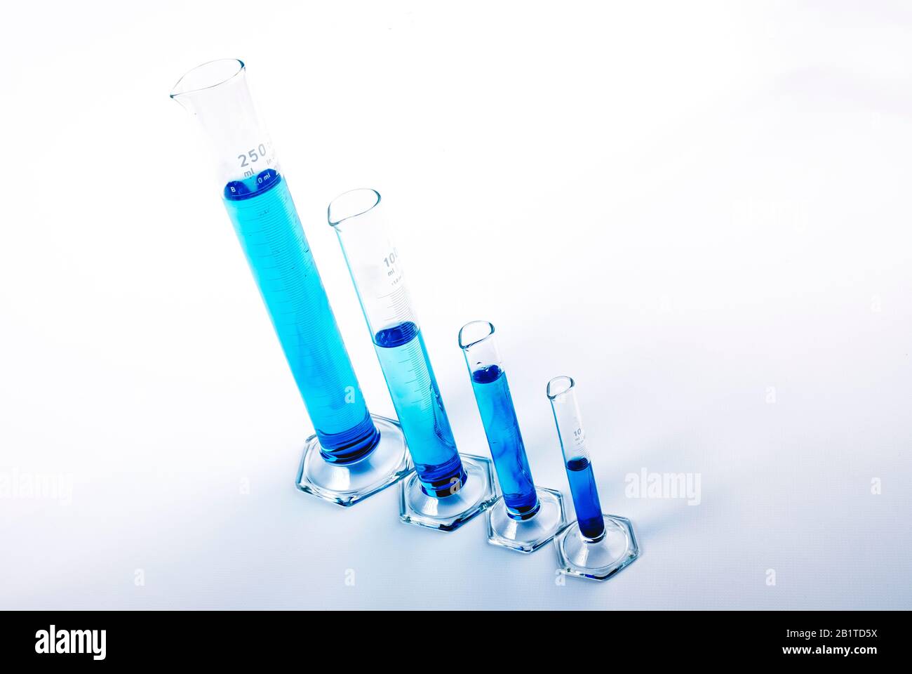 Laboratory test equipment with blue liquid inside on white background ...