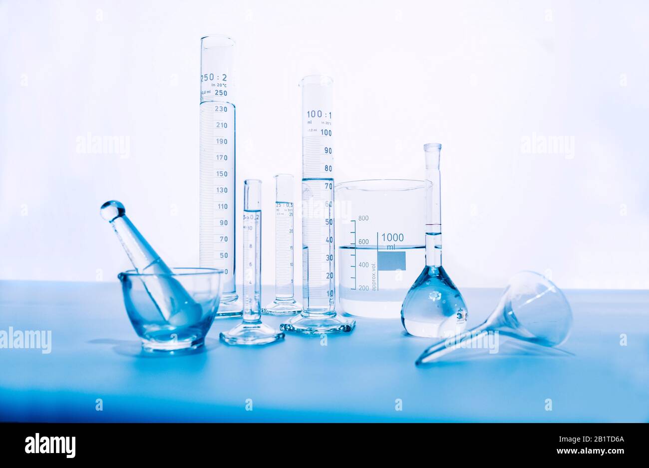 Laboratory test equipment with blue liquid inside on white background ...