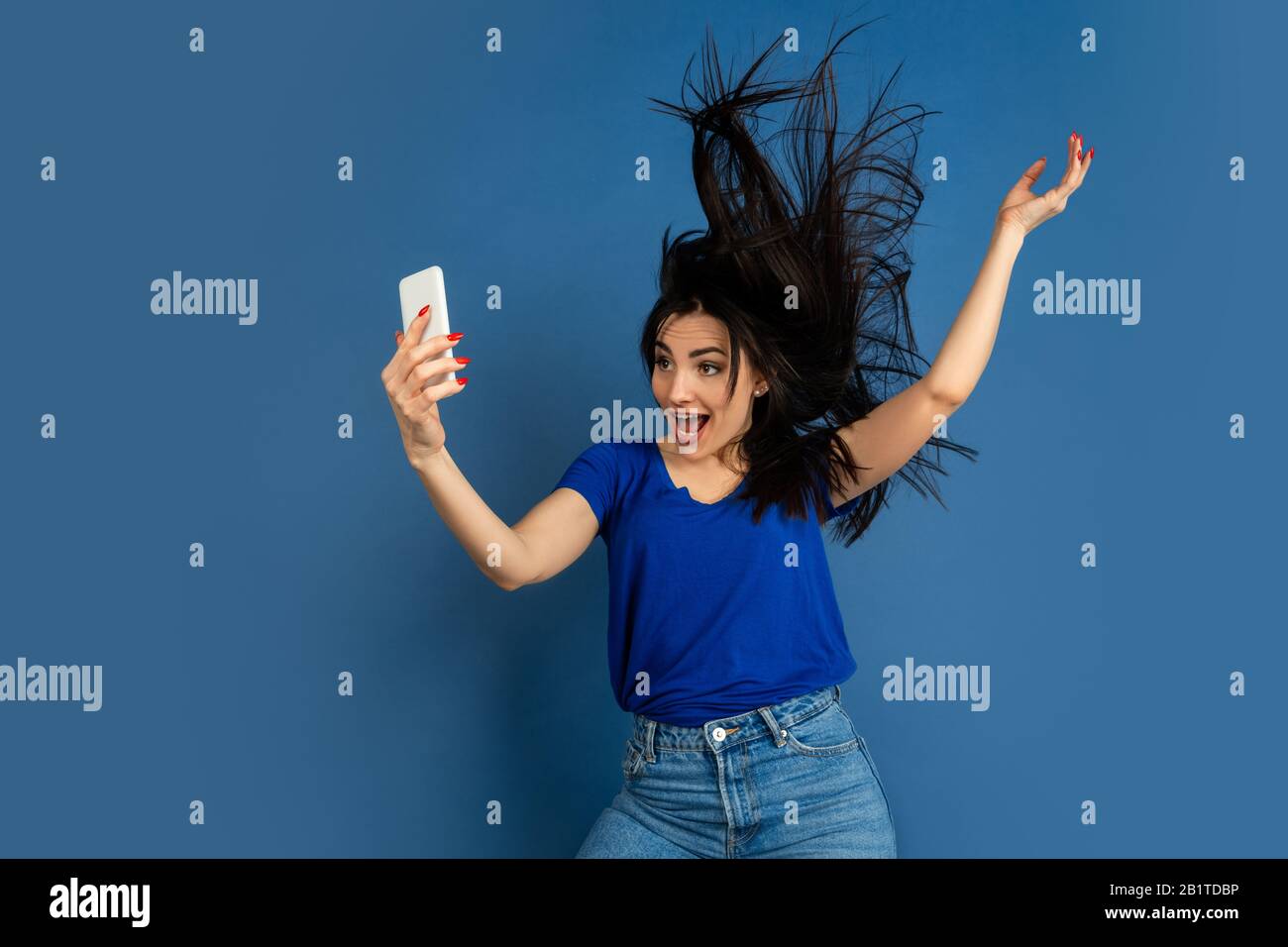 Selfie while dancing. Beautiful caucasian woman's portrait on blue ...