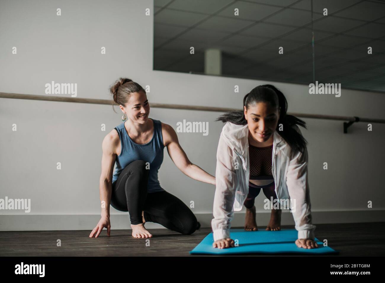 personal trainer coaches her african american client do a push up Stock ...