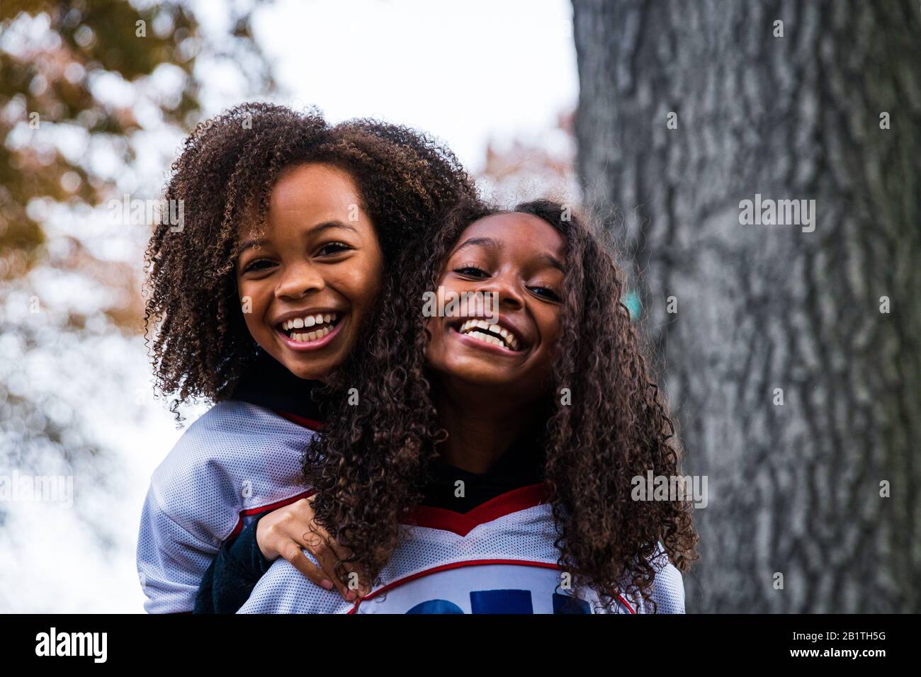 Portrait of cheerful sisters in sports clothing at park Stock Photo - Alamy