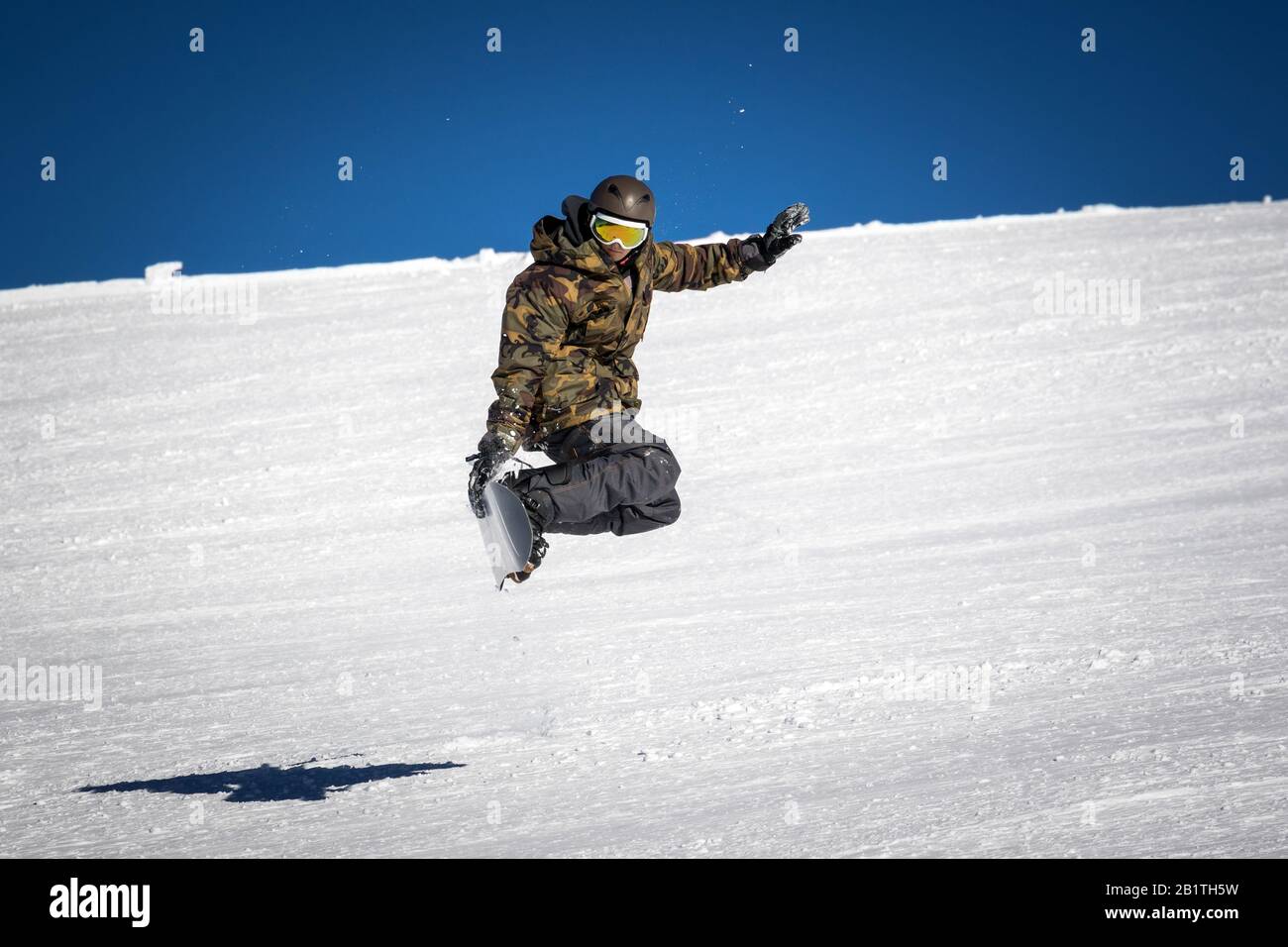 boy jumping with snowboard in fresh snow Stock Photo - Alamy