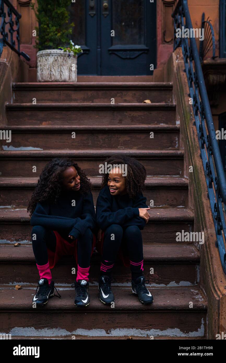 Two sisters sitting on stairs hi-res stock photography and images - Alamy