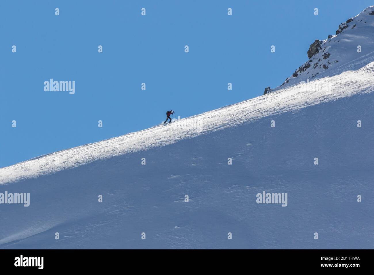 ski mountaineer climbing up the alpine ridge Stock Photo - Alamy