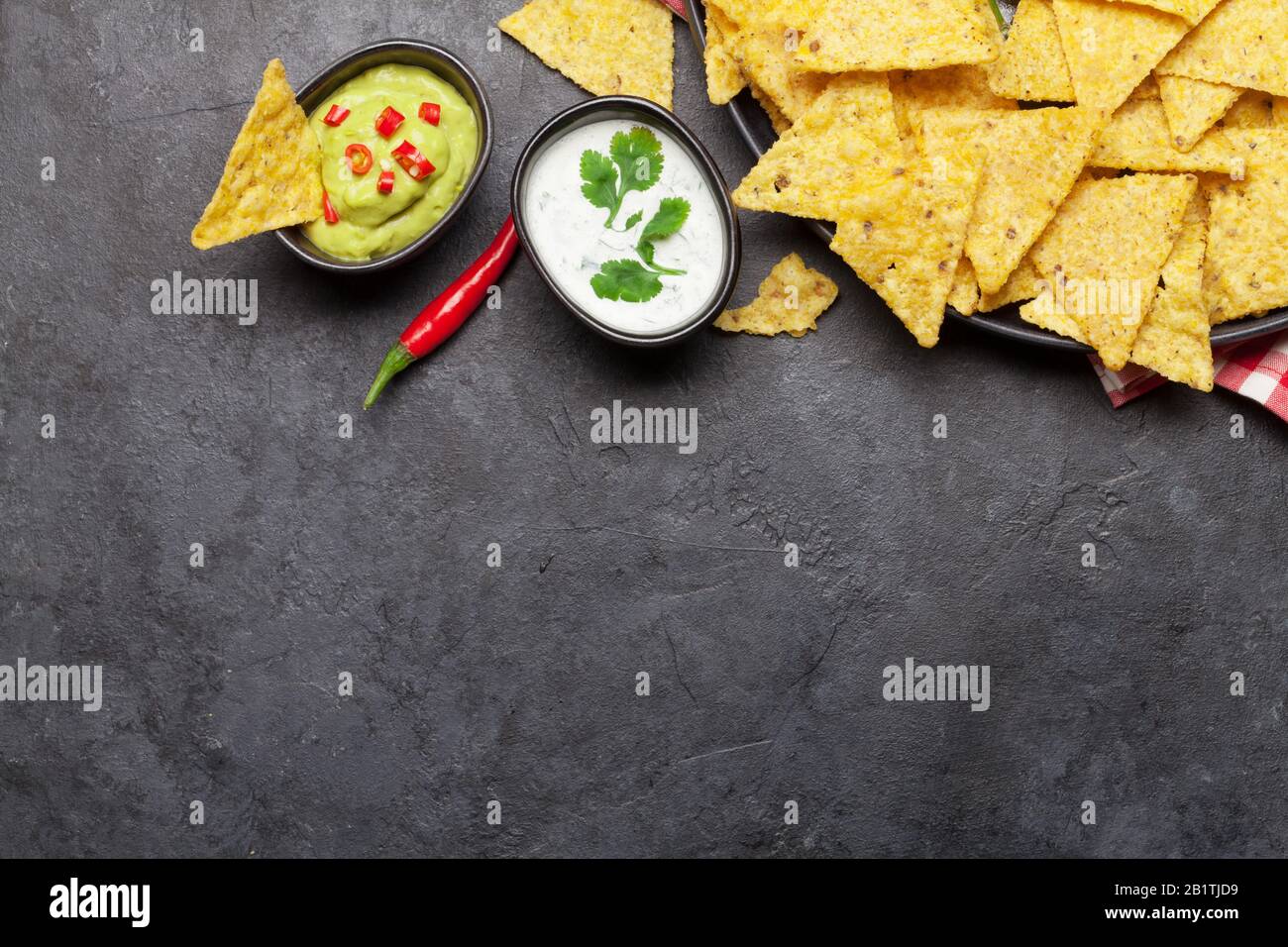 Mexican nachos chips with various sauces - guacamole and sour cream ...