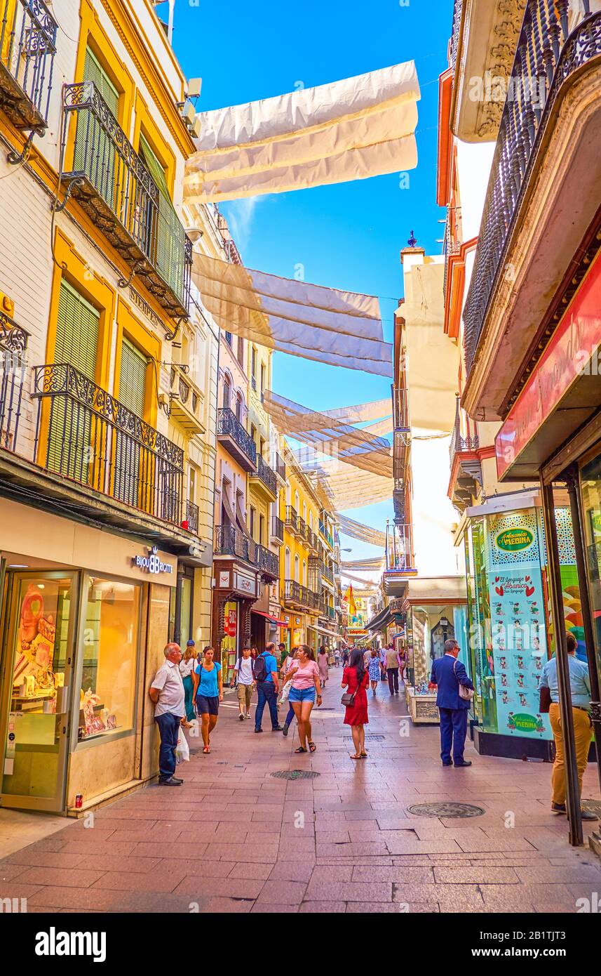 SEVILLE, SPAIN - OCTOBER 1, 2019: The narrow busy shopping street in ...