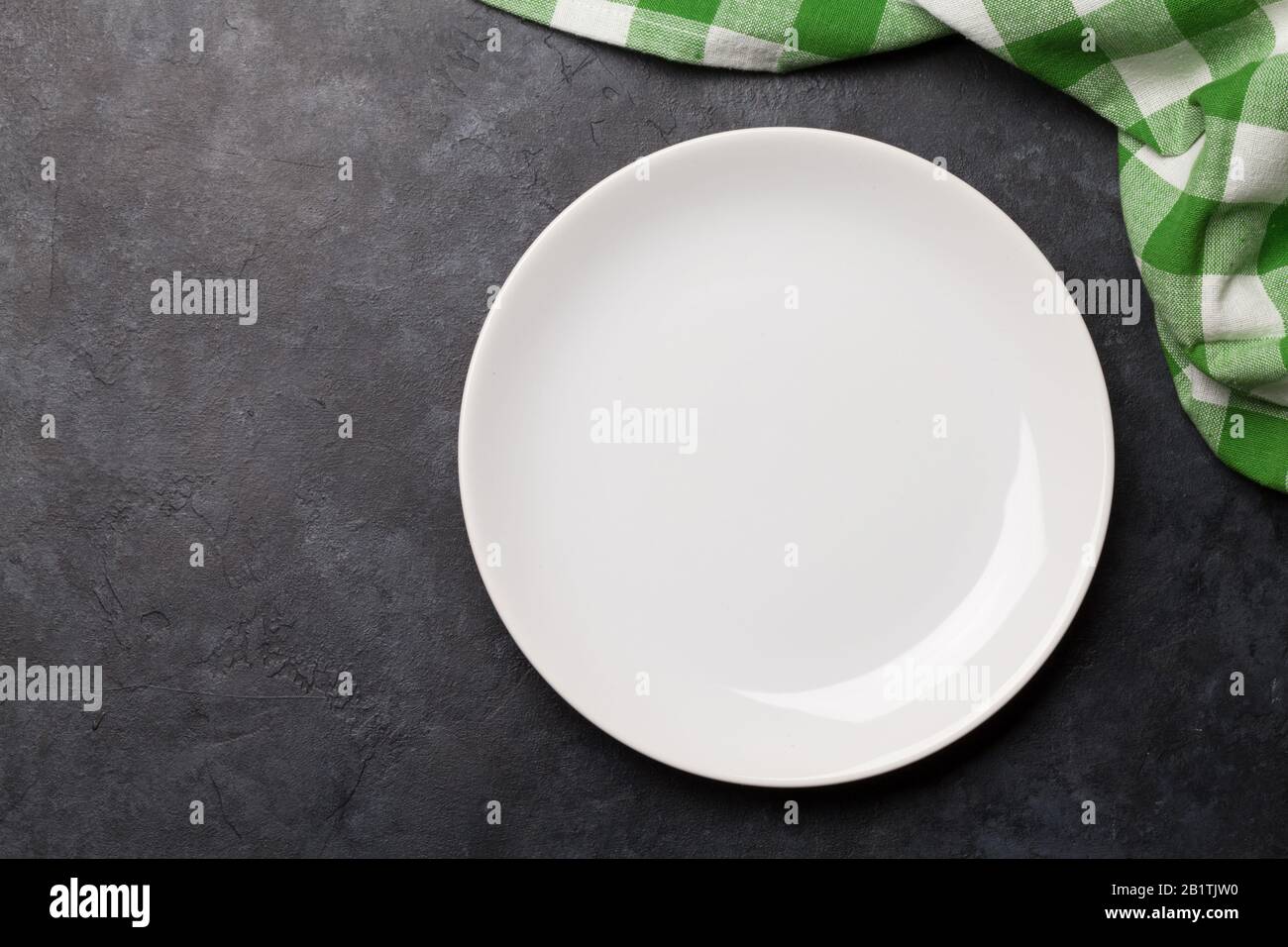 Kitchen table with empty plate, tablecloth and space for your recipe or ...