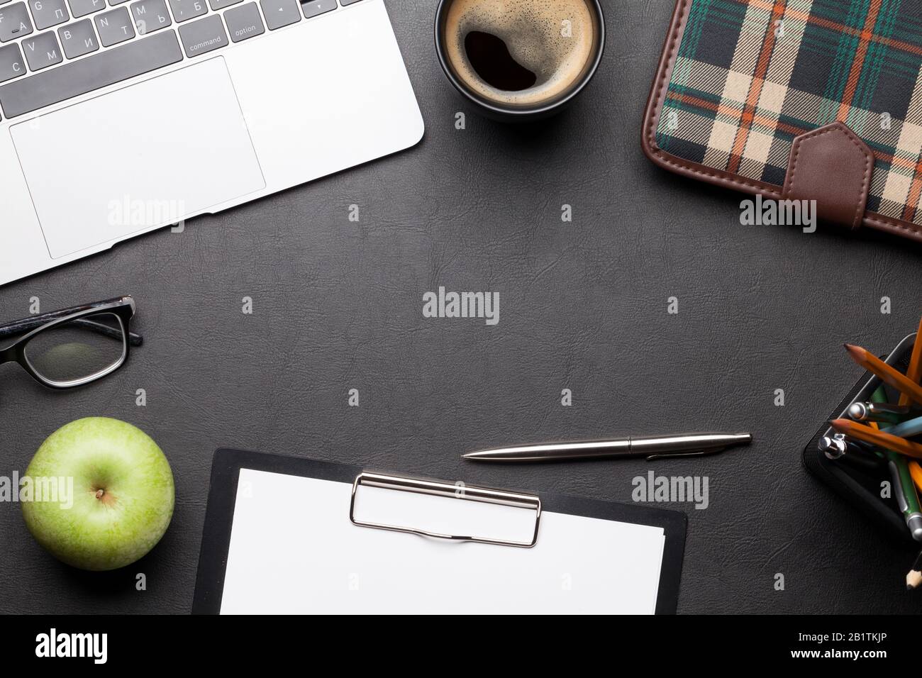 Office desk table with laptop, supplies and coffee. Dark workspace ...