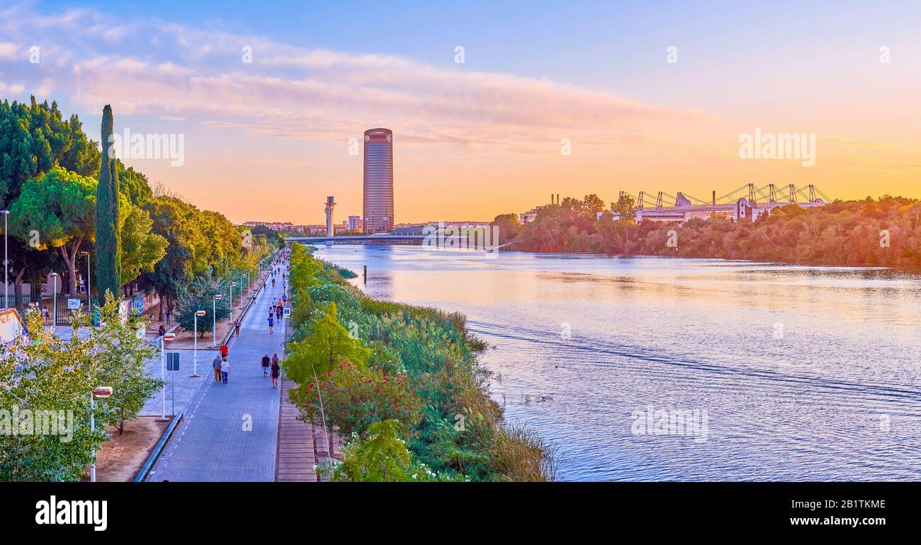 SEVILLE, SPAIN - OCTOBER 1, 2019: The evening walk along Guadalquivir ...