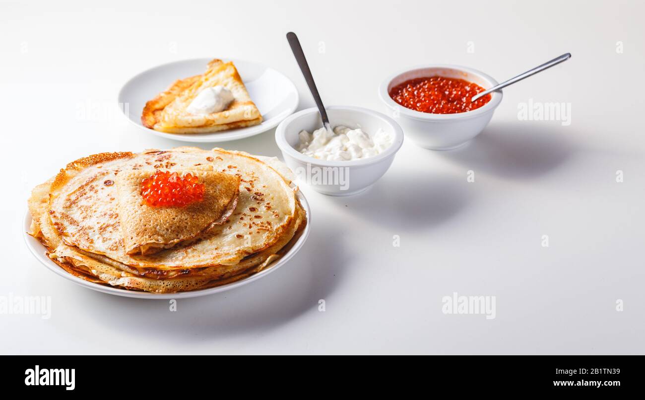 Traditional Russian Crepes Blini stacked in a plate with red caviar ...