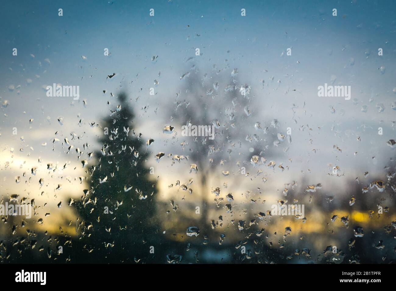 Texture of water drops on window glass and blurry sunrise landscape ...