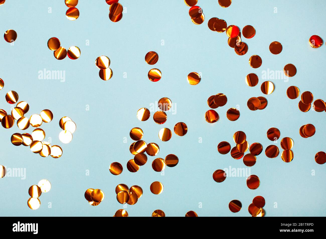 Orange and yellow falling confetti on blue background Stock Photo - Alamy