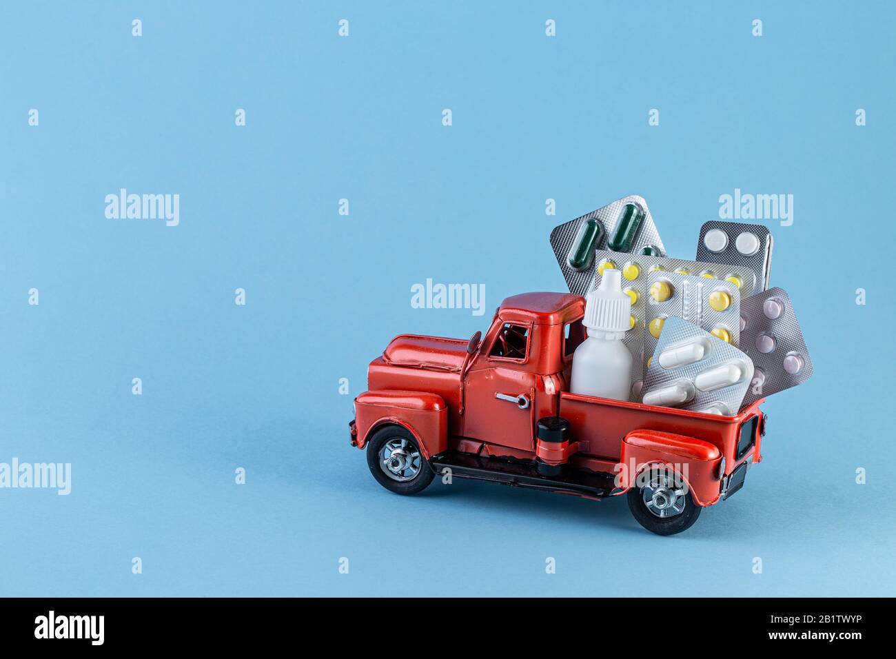 Toy car truck with pills on a blue background. Various capsules ...