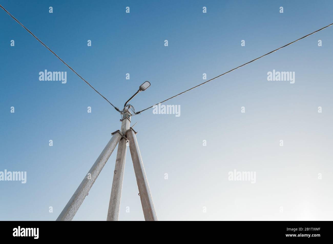 Electric pole on blue sky background in the light of the rising sun ...