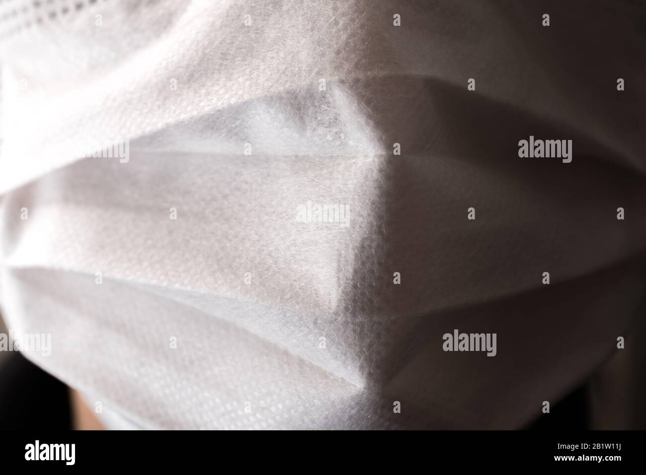 Closeup with the face of a young man wearing medical or surgical mask ...
