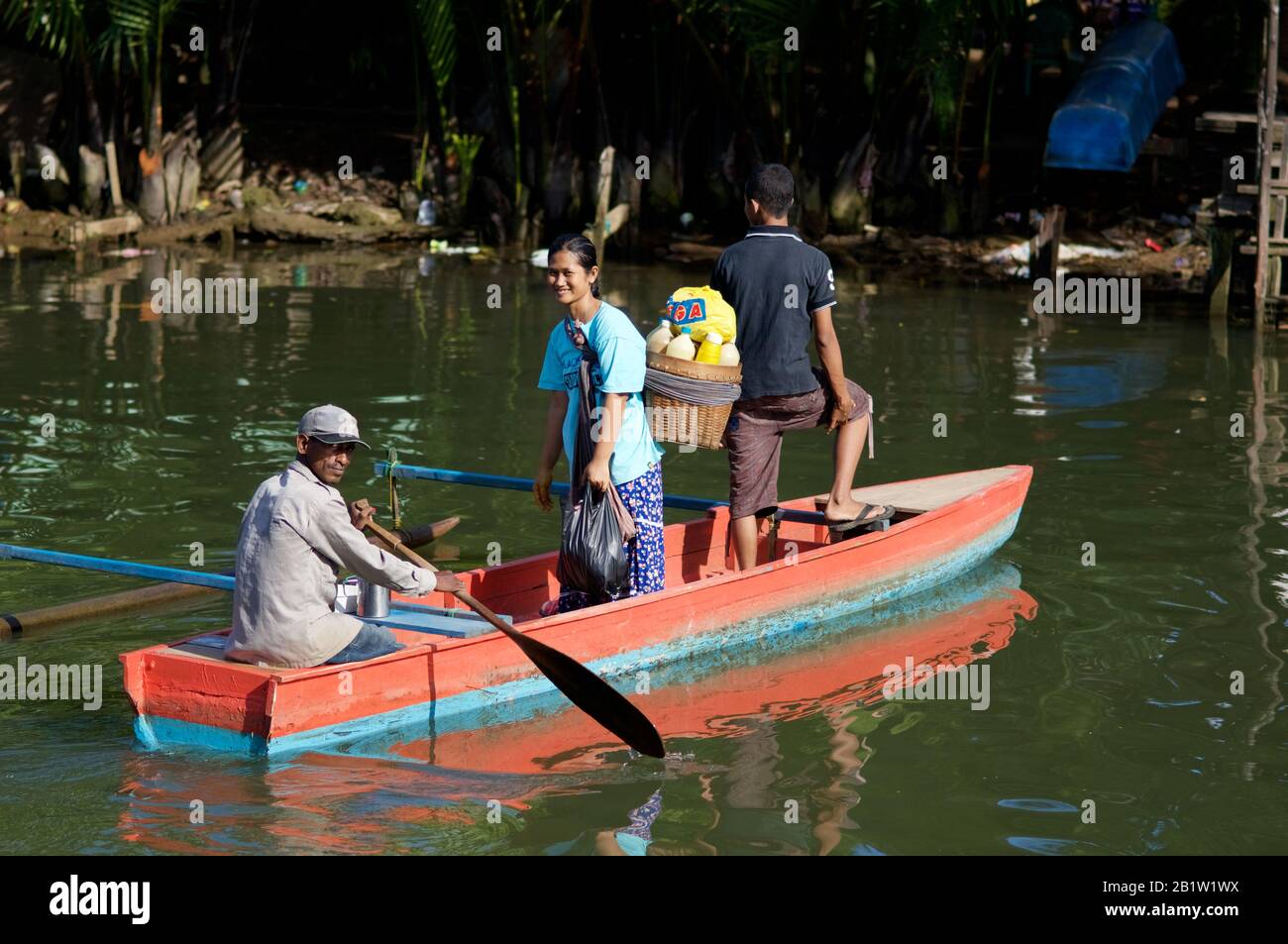Indonesian people crossing river on a wood rowing boat in "Pasar Reimu ...
