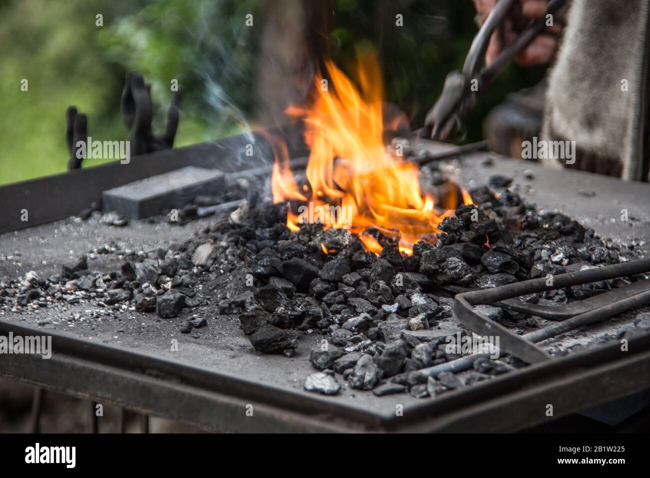 Forge fire with blazing flames and workpiece to be forged Stock Photo ...