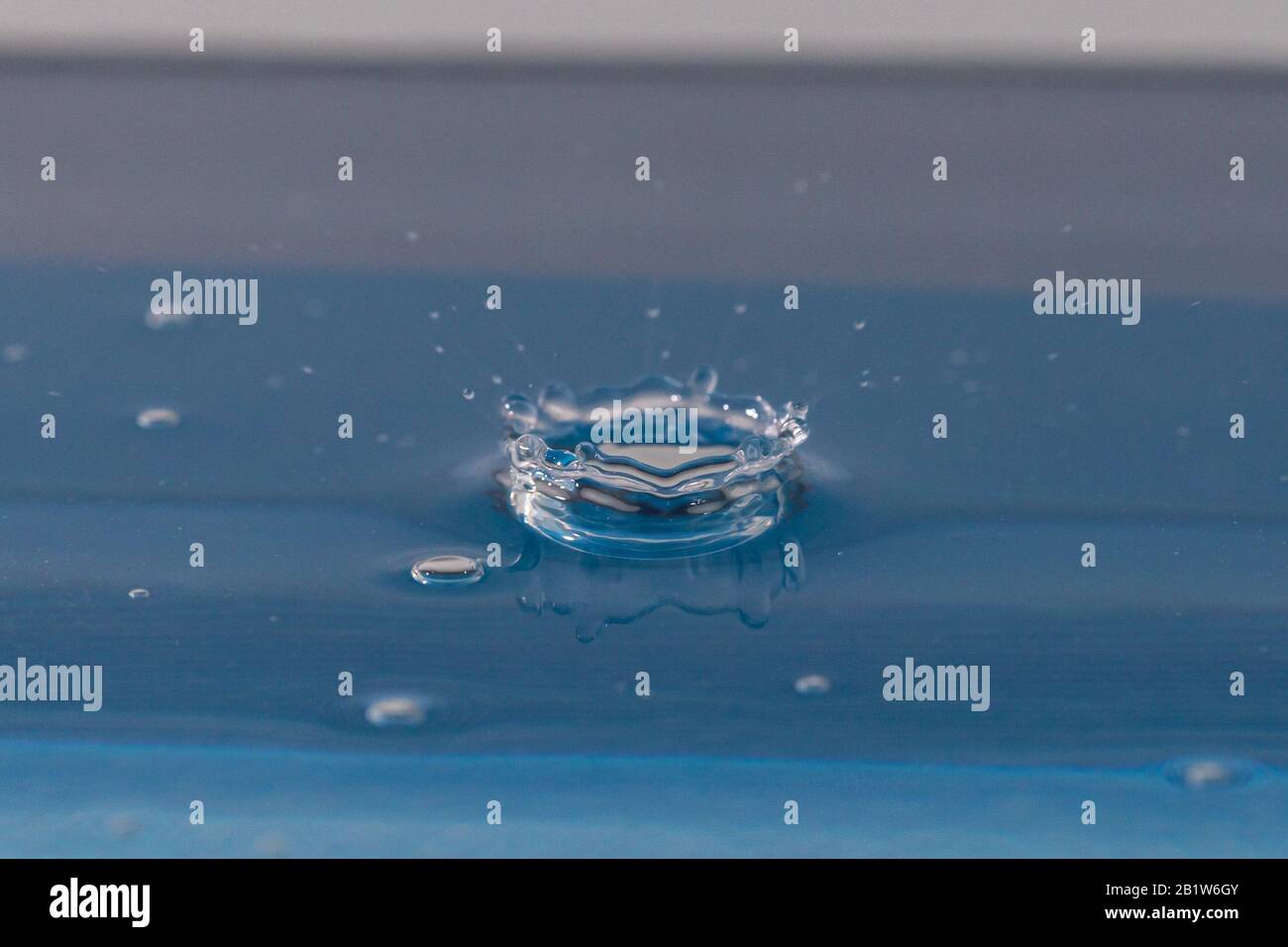 a single drop of water falls into the water from above Stock Photo - Alamy