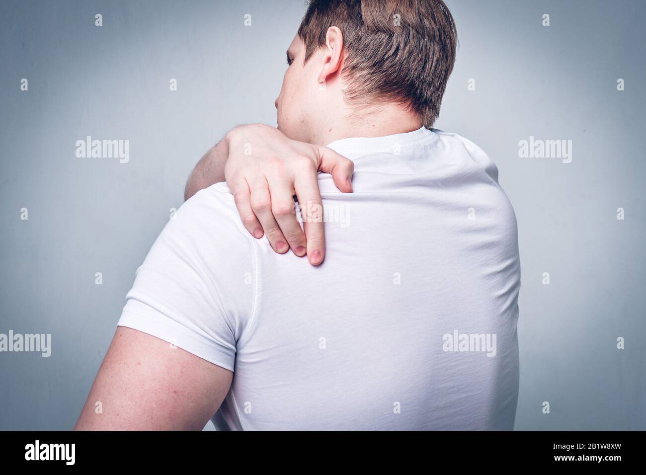 A man massages his neck, scratches his back. Severe itching. Allergy ...