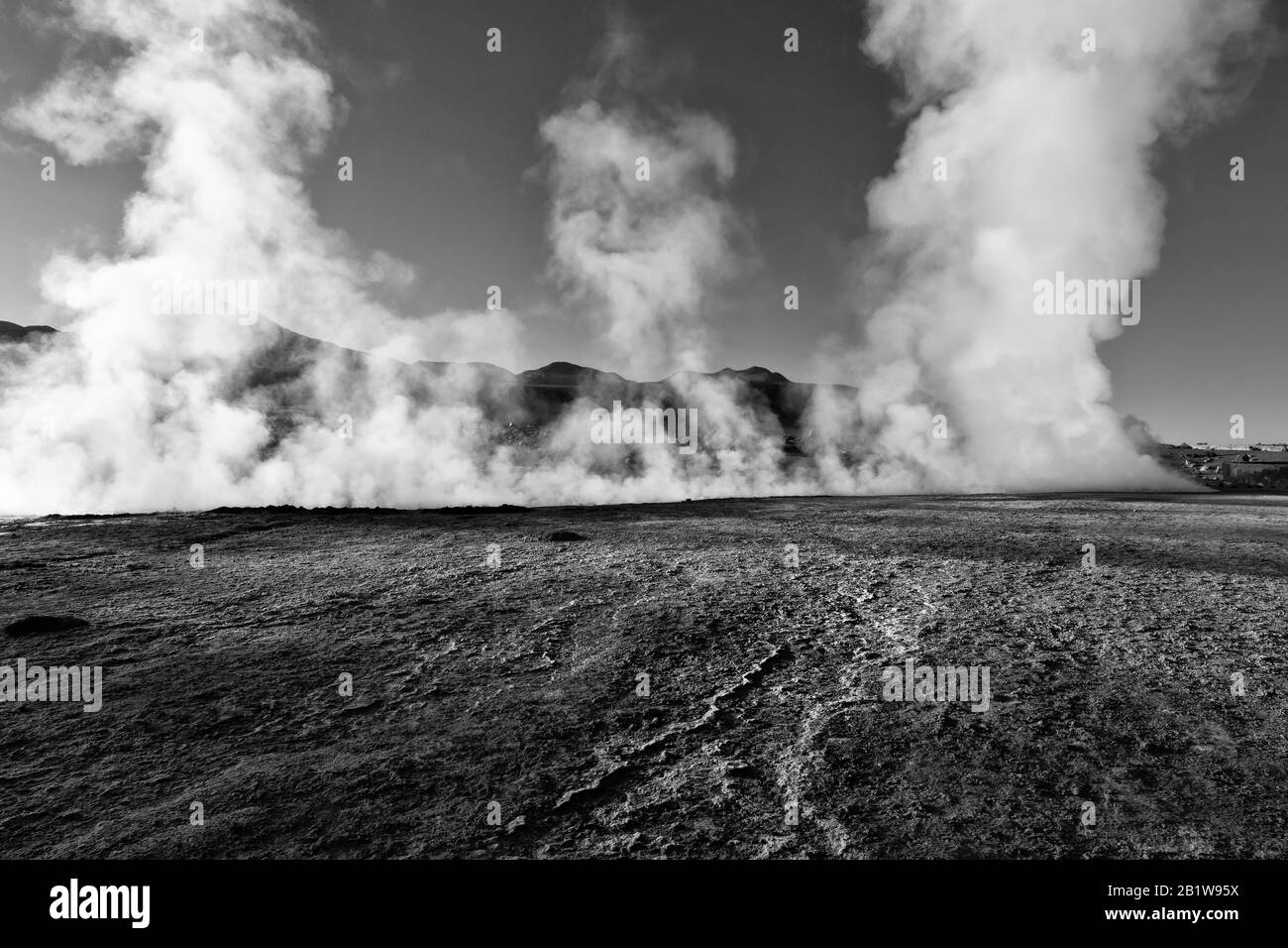 Three geysers and a stream of hot water emit columns of steam at ...