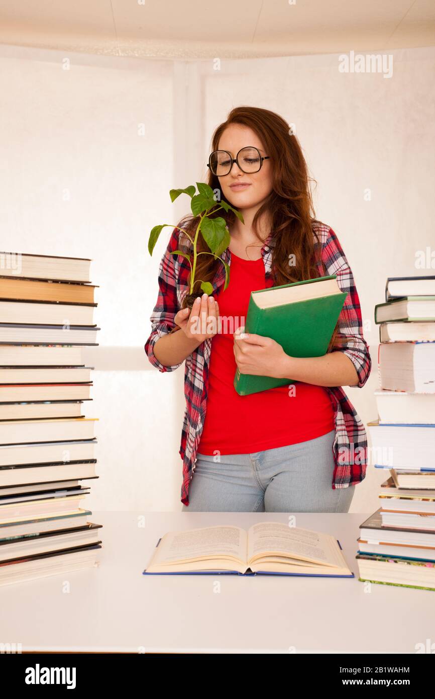 attractive young botany student with seedlnng and books Stock Photo - Alamy